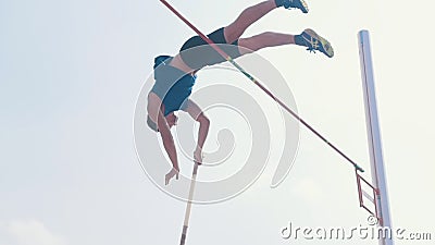 Pole Vault - an Athletic Man Jumping Above the Pole and Falls Down on ...