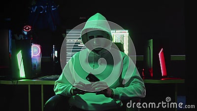 Portrait of a Mysterious Hacker in a Hood, Sitting at a Table and ...