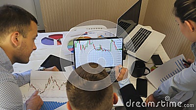 Professional Managers Comparing Sales Result Graphs on Papers with ...