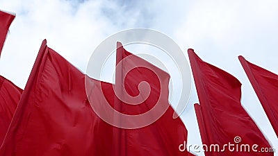 Red Flags Waving in the Wind Against the Backdrop of Fast-Moving Clouds ...