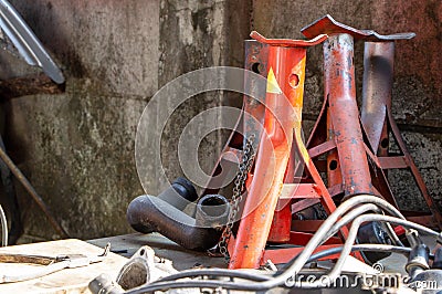 Red Rusty Jack Stand On A Table With Another Used Engine Part In A ...