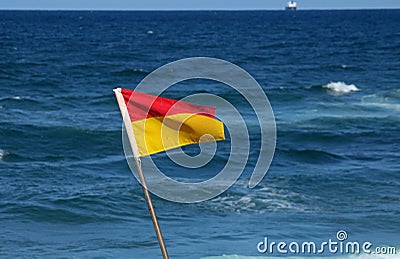 RED AND YELLOW LIFEGUARD FLAG WITH SEA IN BACKGROUND Royalty-Free Stock ...