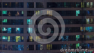 Rows of Glowing Windows with People in Apartment Building at Night ...