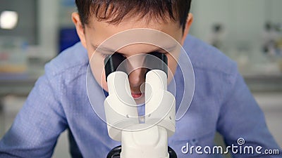 School Child Looking into Microscope Doing a Science Experiment in ...