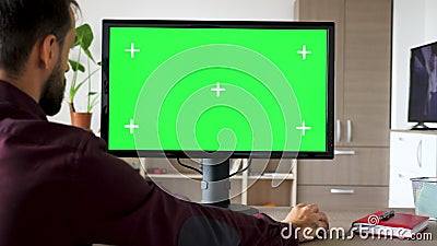 Side View of Man Sitting in Front of Computer with Big Green Screen ...