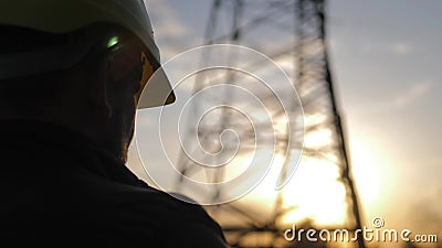 Silhouette of Engineer Standing on Field with Electricity Towers ...