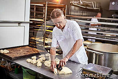 Skilled Man Baker Dividing Raw Dough Into Equal Portions And Weights ...