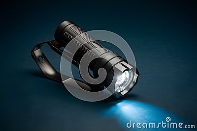Sleek Black Flashlight With Textured Grip And Bright White Beam On Blue ...