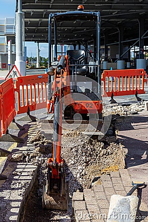 A Small Digger Digging Up The Pavement During Ground Works Editorial ...