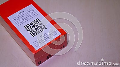 Smartphone Scanning QR Code in Paper Label on the Orange Package or ...