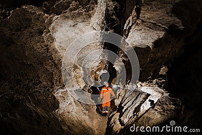 Speleologist Descend By The Rope In The Deep Vertical Cave Tunnel ...