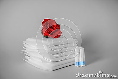 Stack Of Menstrual Pads With Red Rose And Tampons On Grey Background ...