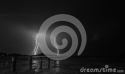 Stunning Grayscale Shot Of A Distant Lightning Strike From A Pier Stock ...