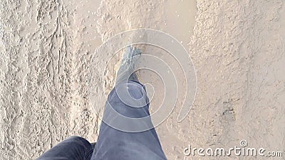 The Swamp at a Construction Site. Men`s Feet in Rubber Boots are in the ...