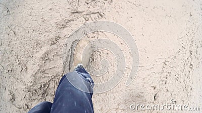 The Swamp at a Construction Site. Men`s Feet in Rubber Boots are in the ...