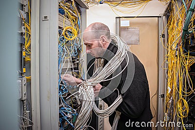 The Technician, All Wrapped In Cables, Connects The Wires In The Rack ...