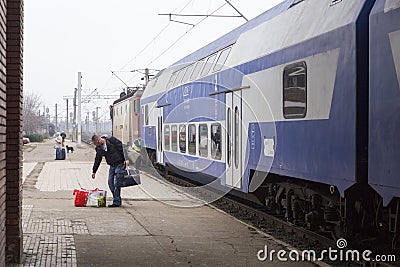 Passenger Getting Off The Train And Picking Up His Bags Editorial Photo ...