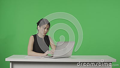 The TV Presenter Sits at a Table Against the Background of a Green ...