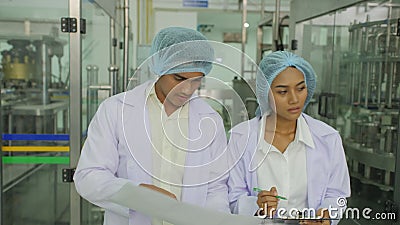 Two Engineers In White Uniform Control Production Process In A Factory ...
