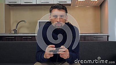 Upset Young Man is Sitting on the Couch, Hold Gamepad in His Hands ...