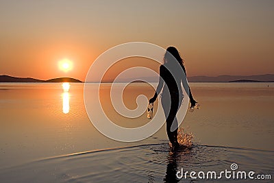 Woman Walking In Sea At Sunset Royalty Free Stock Images - Image: 12101909