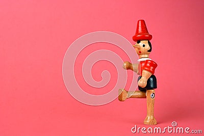 Wooden Puppet Depicting Pinocchio Walking On A Pink Background ...