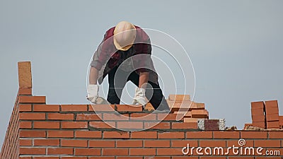 Worker Builds Wall of Bricks. Builder on Building Making Bricklaying ...