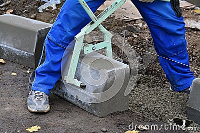 Worker Lifts Concrete Curb With A Manual Lifting Tool. Stock Photo ...