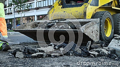 A Worker Loads Old Asphalt into a Tractor Bucket with a Shovel. Stock ...