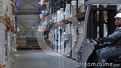 The Worker Moves on a Lifting Machine through a Logistic Warehouse. 4K ...
