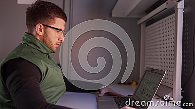 Worker in Uniform Uses Laptop Sitting at His Desk in the Warehouse ...