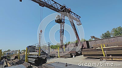 Workers Unload a Sheet of Metal in a Truck Standing Under a Gantry ...