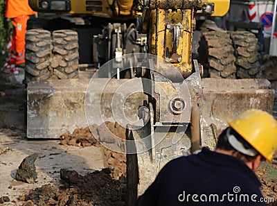 Works On A Road Construction Site With The Digger And The Worker Stock ...