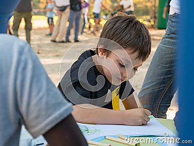 Young Boy Drawing On A Paper With Colored Pencil In A Park Royalty-Free ...