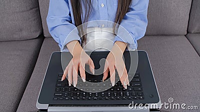 Young Girl Typing Text on a Laptop Keyboard while Sitting on a Couch at ...
