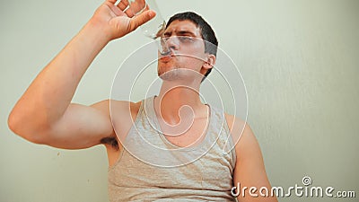 A Young Guy with Bruised Eye in an Alcoholic Intoxication Drinks Vodka ...