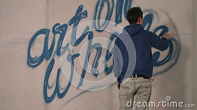 Young Man Drawing Graffiti On A Wall With A Spray Can Stock Footage ...