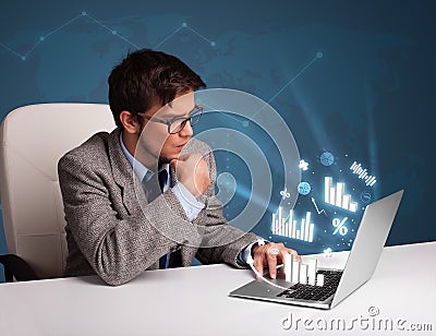 Young Man Sitting At Desk And Typing On Laptop With Diagrams And ...