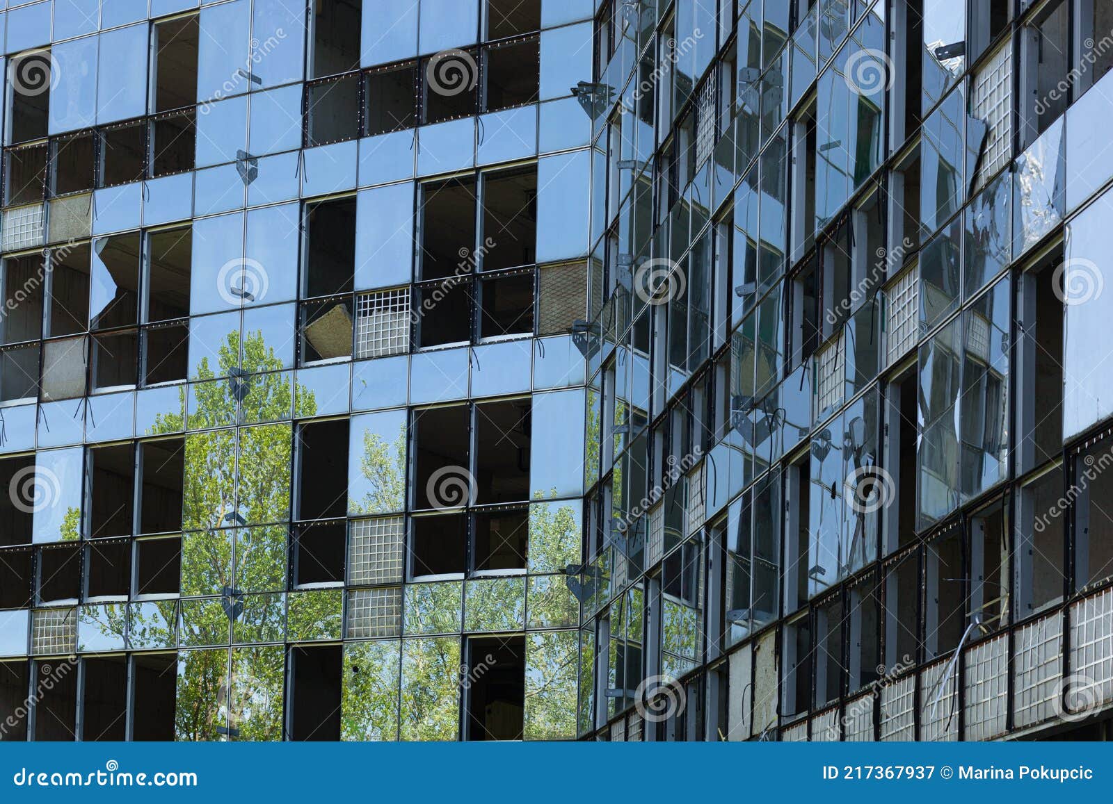 Abandoned Modern Glass Building with Broken Windows and Reflection of ...