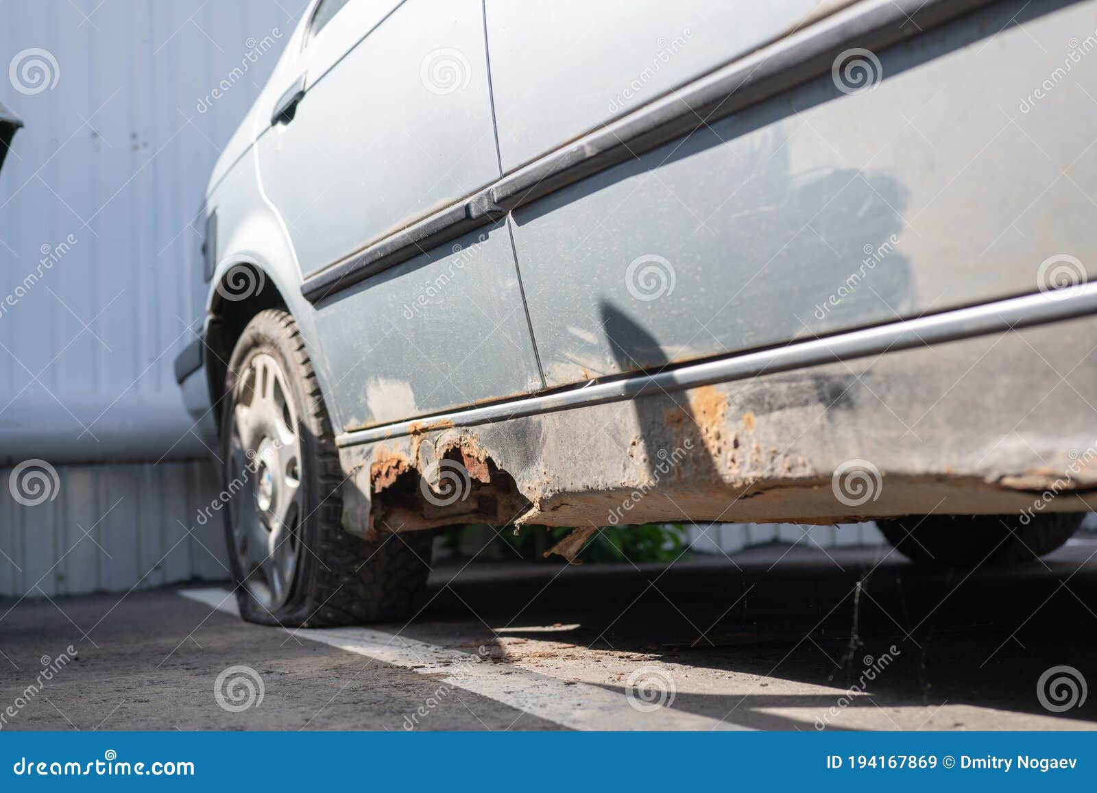 Abandoned Rusty Car with a Rotten Sill and a Flat Tire Stock Image ...
