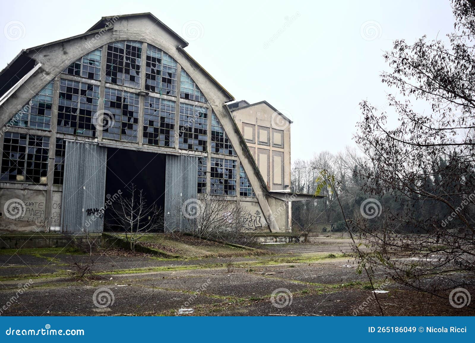 Abandoned Warehouse with Broken Windows in a Park on a Cloudy Day in ...