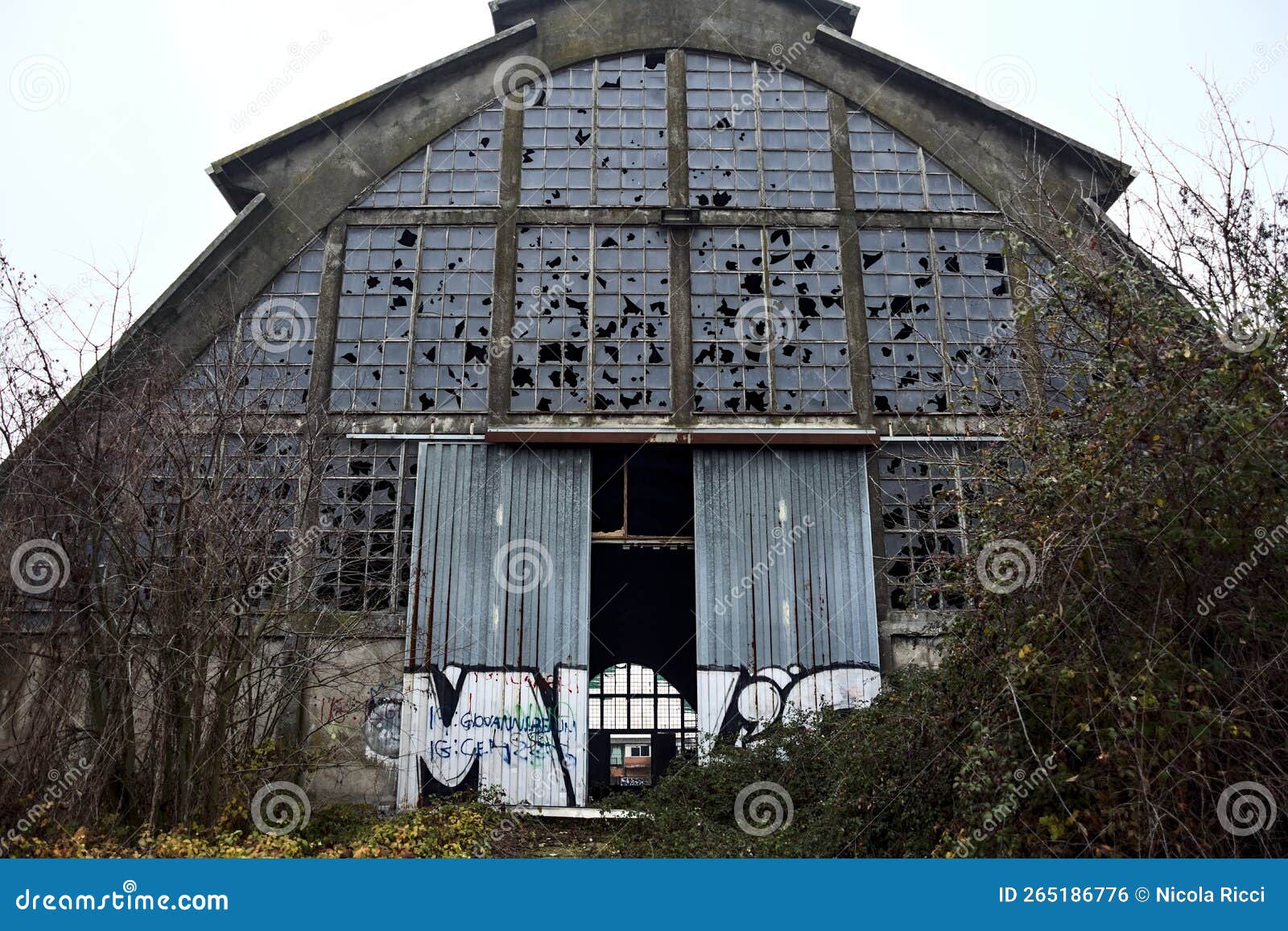 Abandoned Warehouse with Broken Windows in a Park on a Cloudy Day in ...