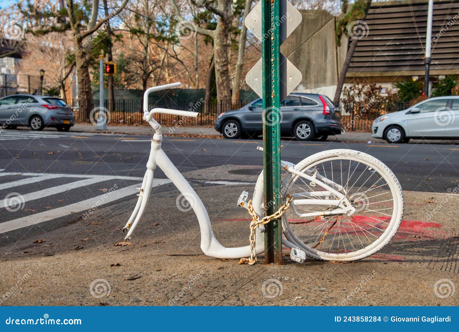 Abandoned White Bicycle with One Wheel Chained To a Pole Along a City ... Abandoned White Bicycle with One Wheel Chained To a Pole Along a City ...