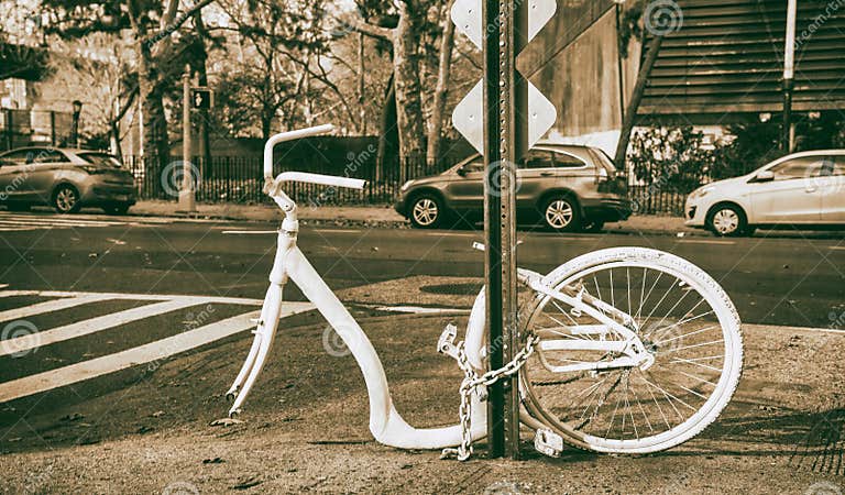 Abandoned White Bicycle with One Wheel Chained To a Pole Along a City ... Abandoned White Bicycle with One Wheel Chained To a Pole Along a City ...