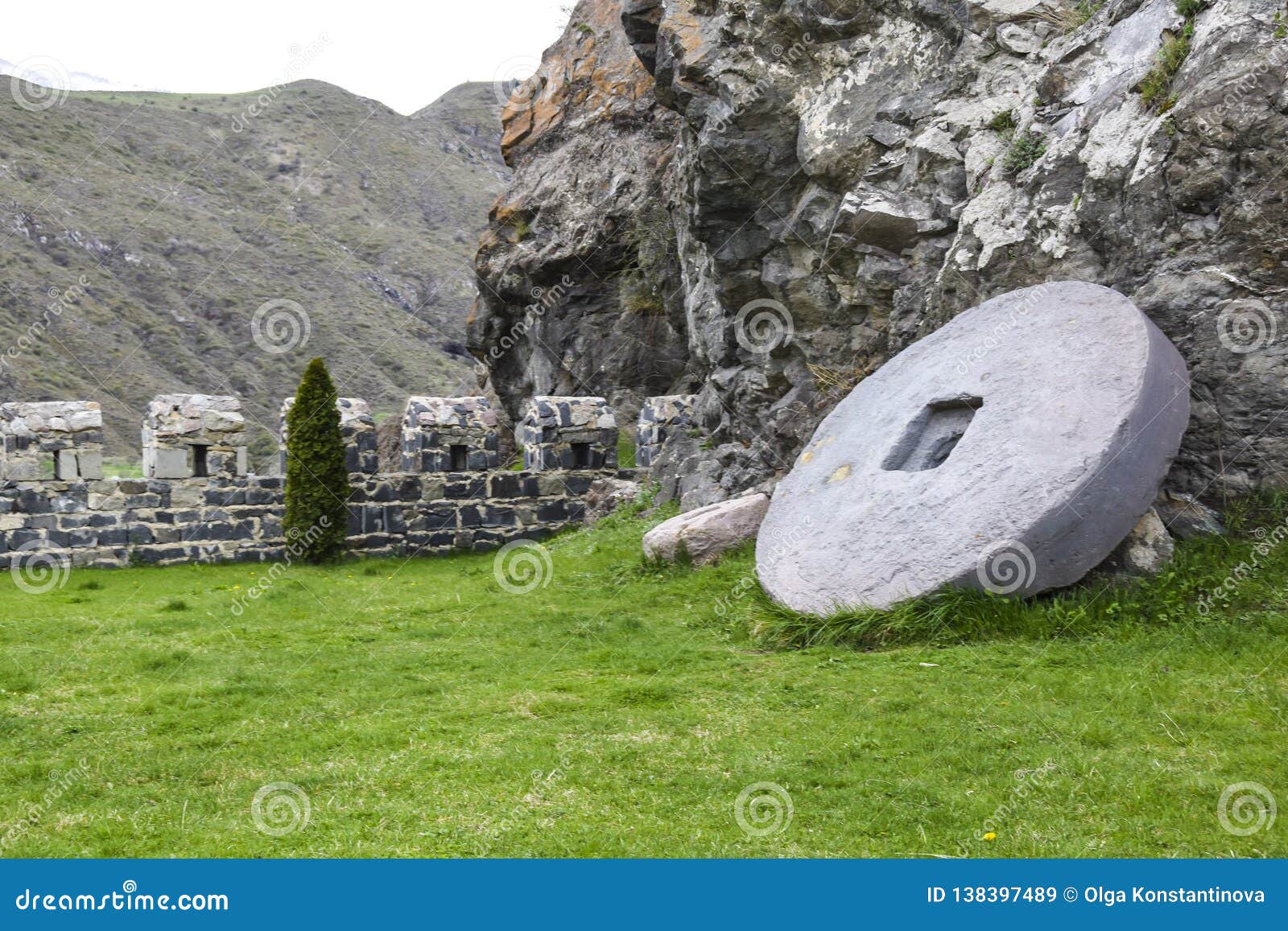 Abstract Round Stone Slab Lies on the Grass Leaned Against Mountain ...