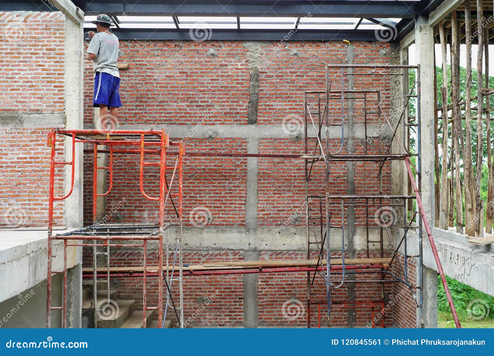 A Bricklayer On Scaffolding Directs The Delivery Of Bricks From A ...