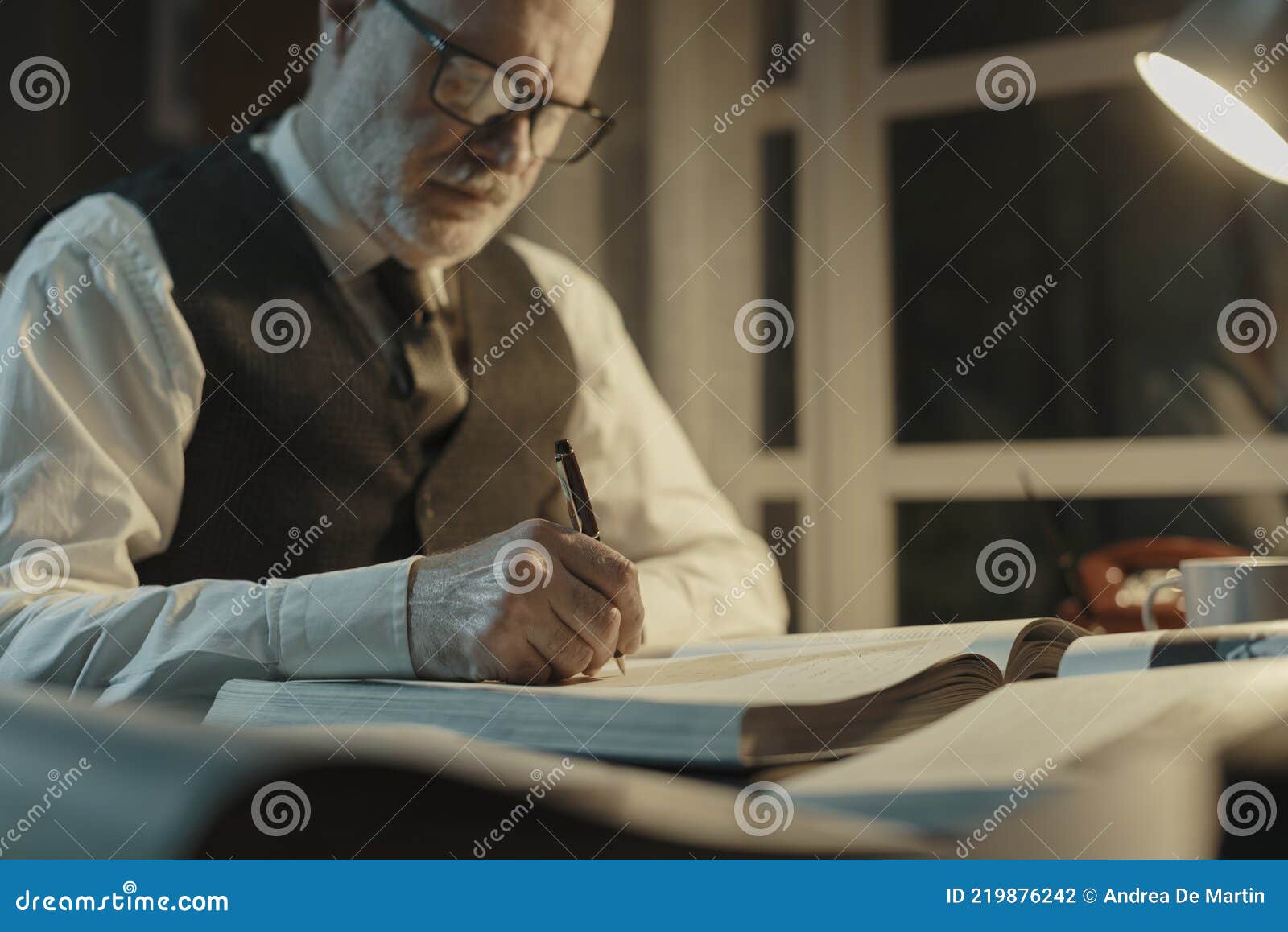 Academic Professor Writing Down Notes and Reading a Book Stock Photo ...