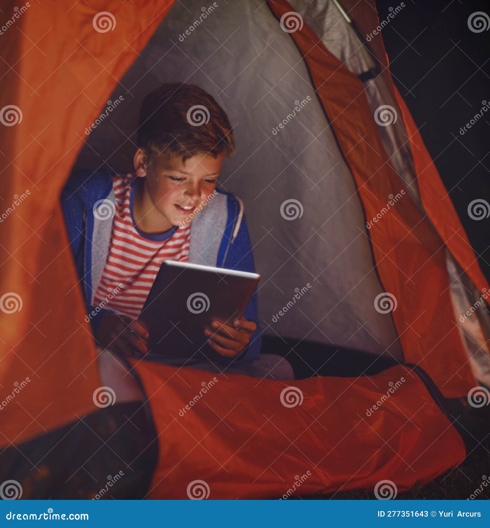 Accessing the Web from His Tent. a Young Boy Using a Digital Tablet ...