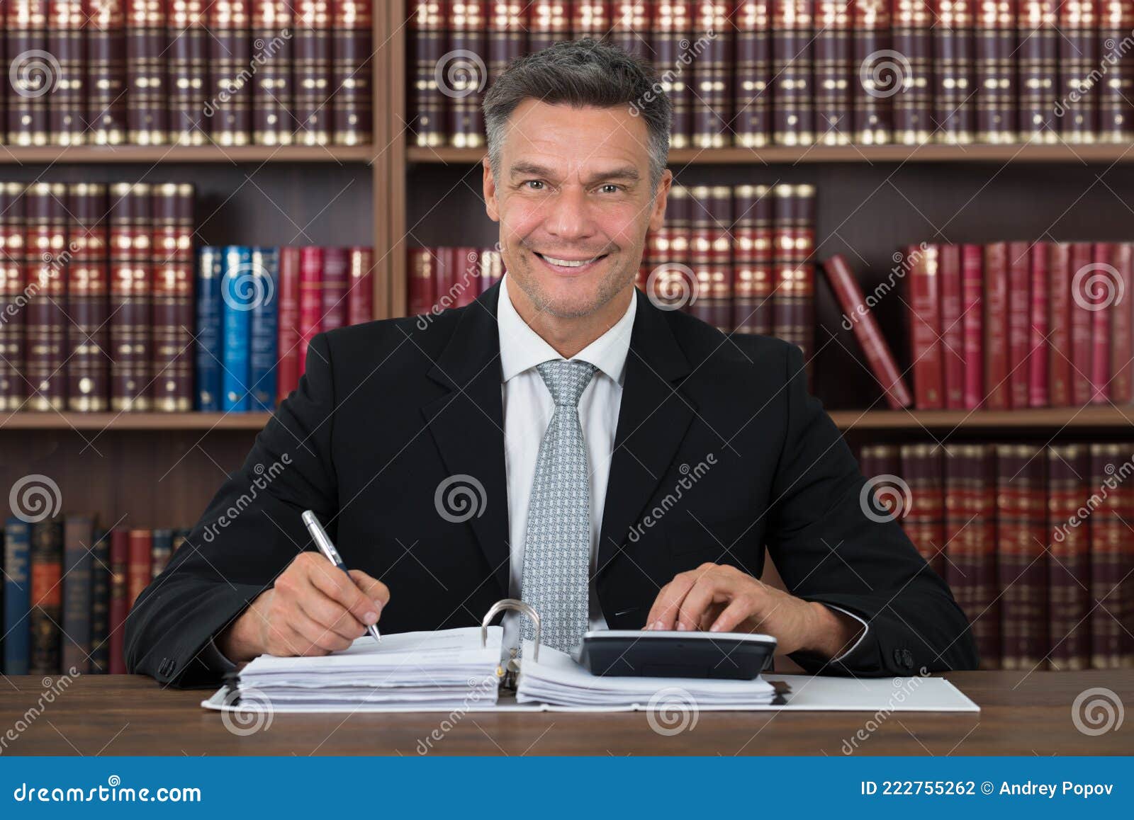 Accountant Writing on Document while Using Calculator at Table Stock ...