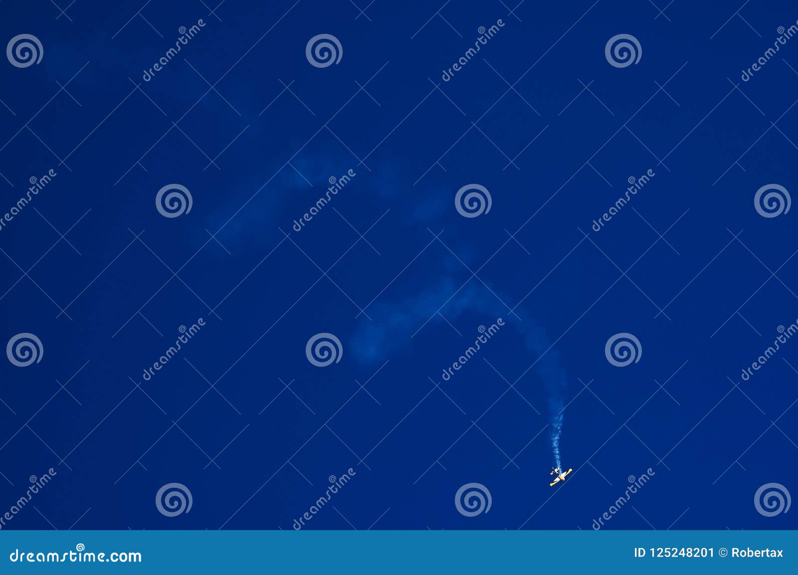 Acrobatic Aeroplane with White Spiral Smoke Trail on Blue Sky Stock ...